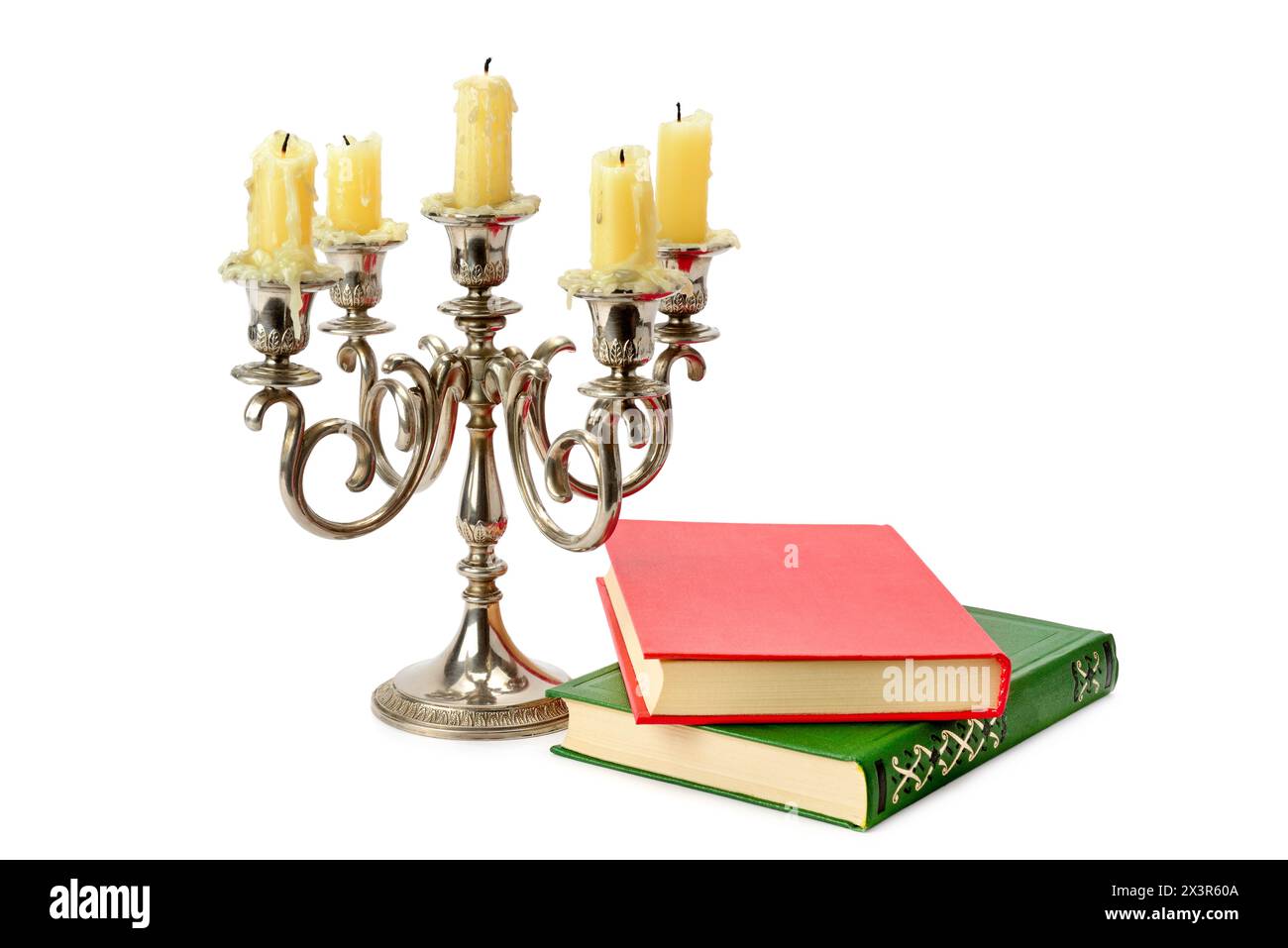 Old candlestick with candles and book isolated on white background ...