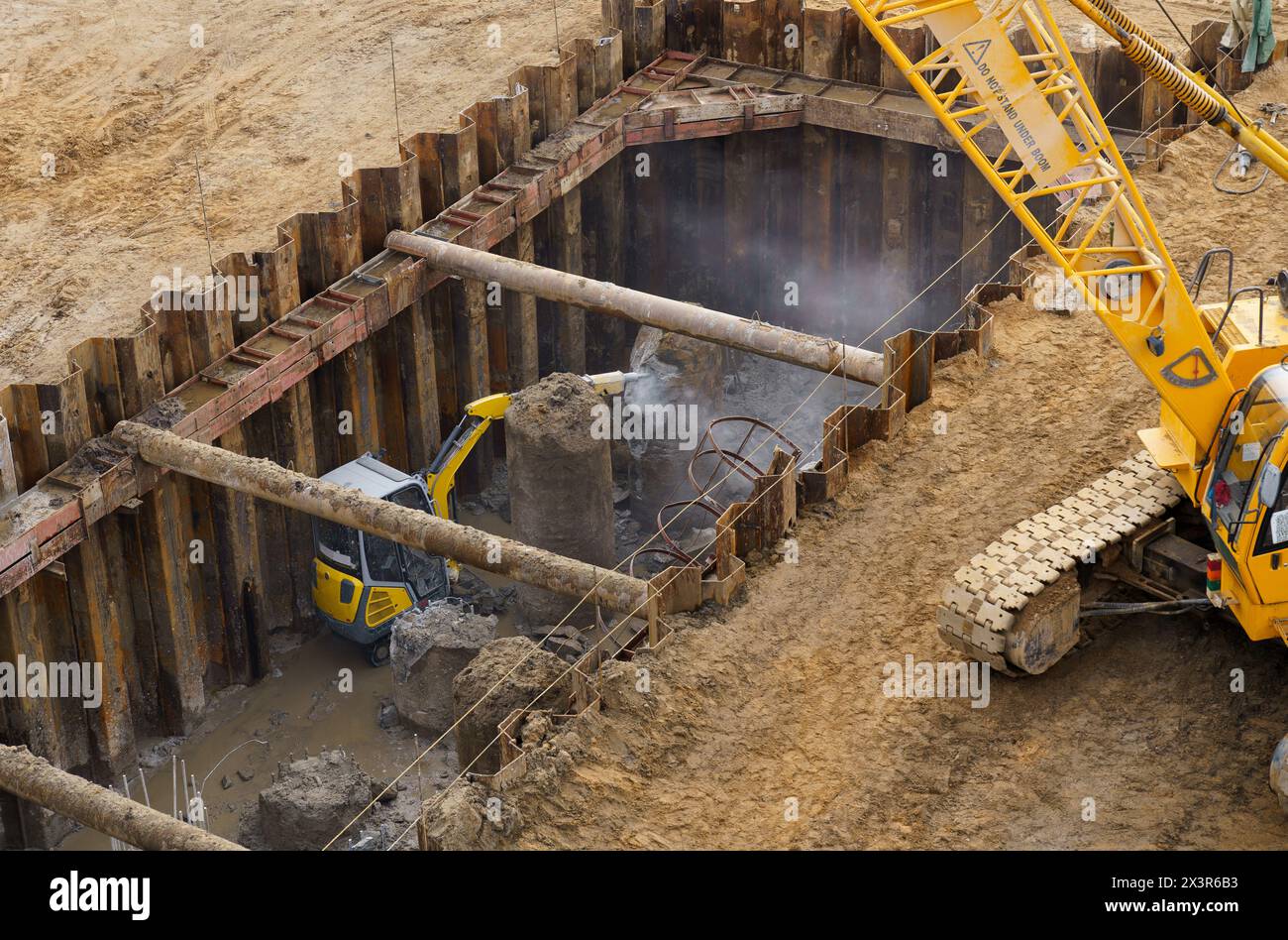 A construction site bustling with activity, featuring a large yellow ...