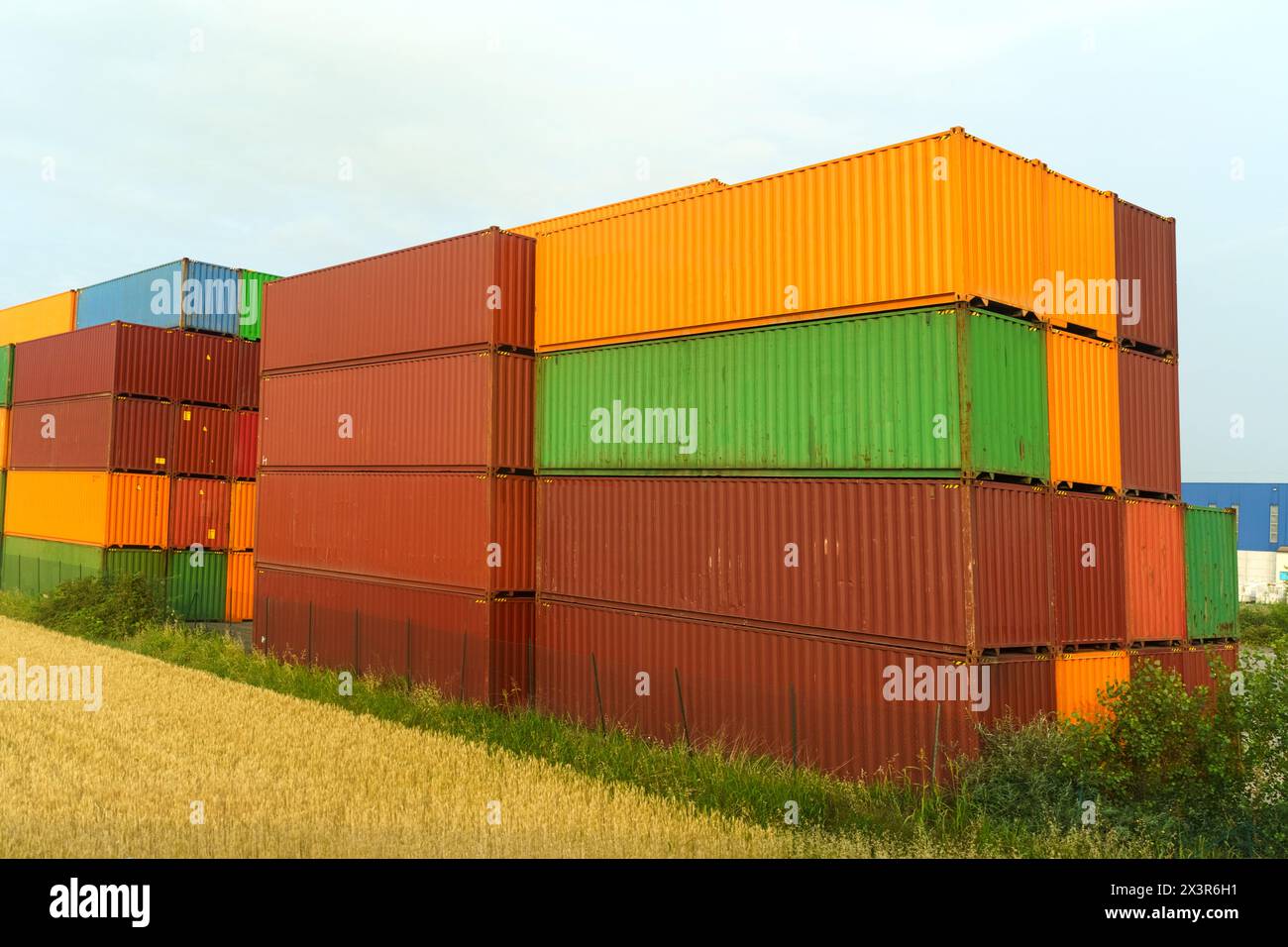 Colorful shipping containers piled high against a clear sky near the ...