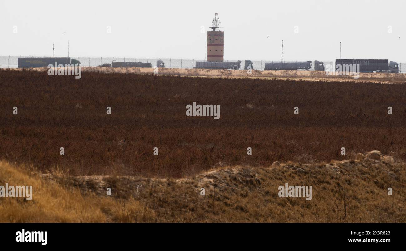 Humanitarian aid trucks lined up inside Egypt near and Egyptian guard ...