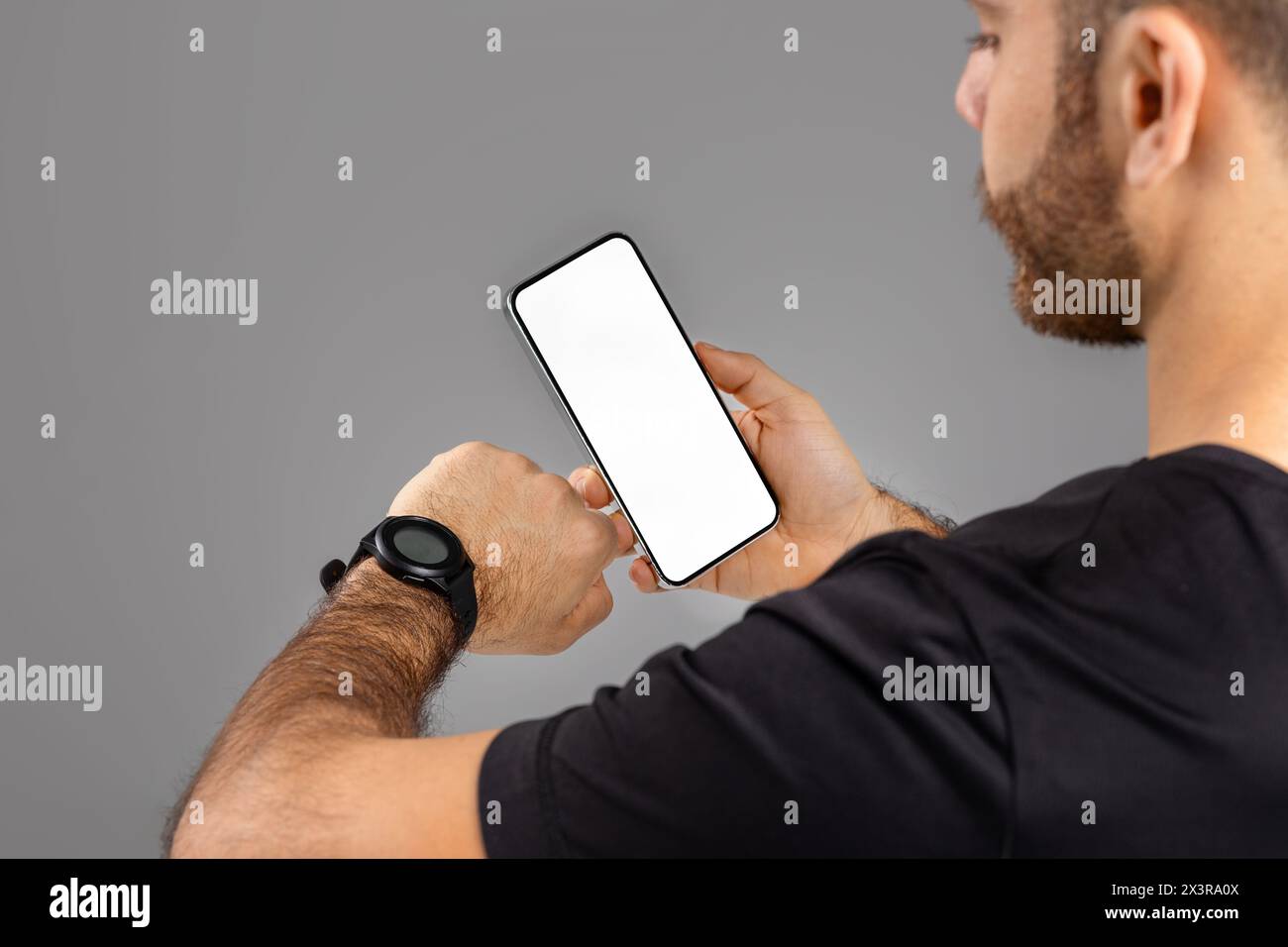 Man in Black Shirt Checking Smartwatch and Holding Smartphone Stock ...