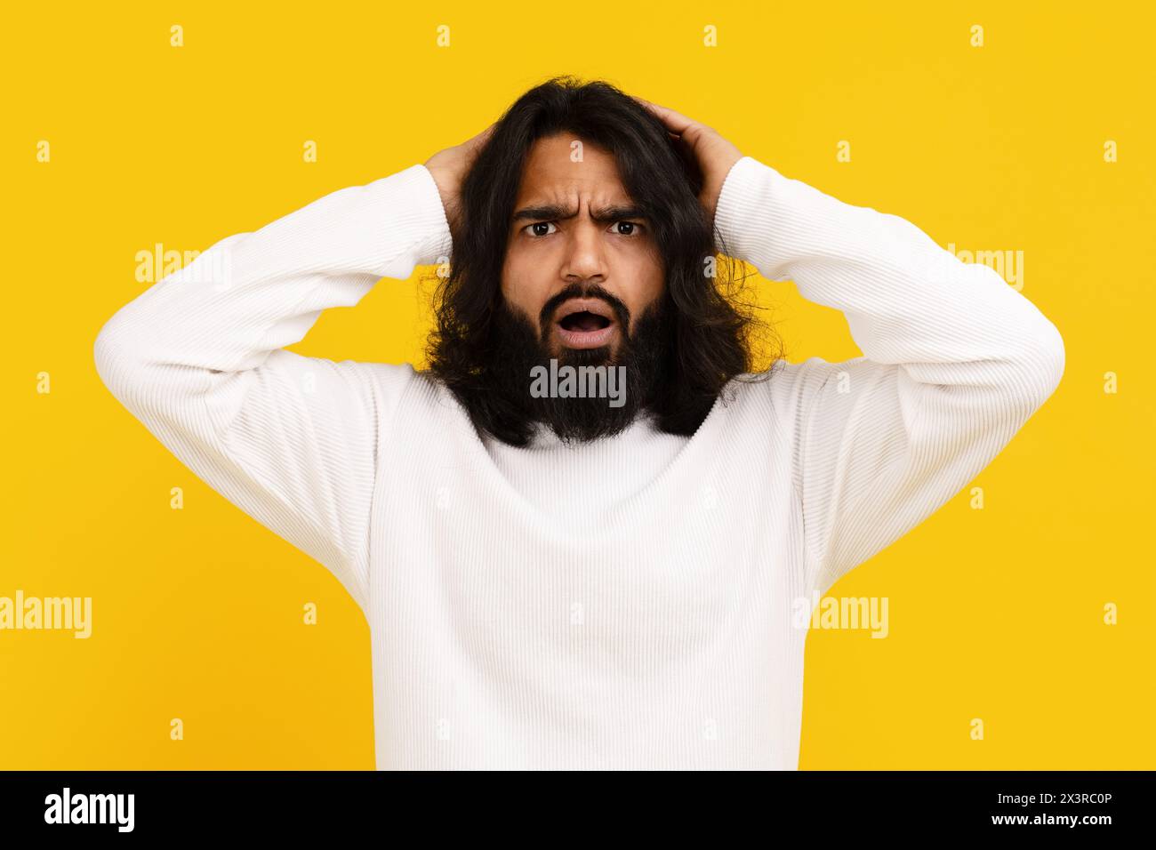 Frustrated Man Grasping His Head in Disbelief Against Yellow Stock ...