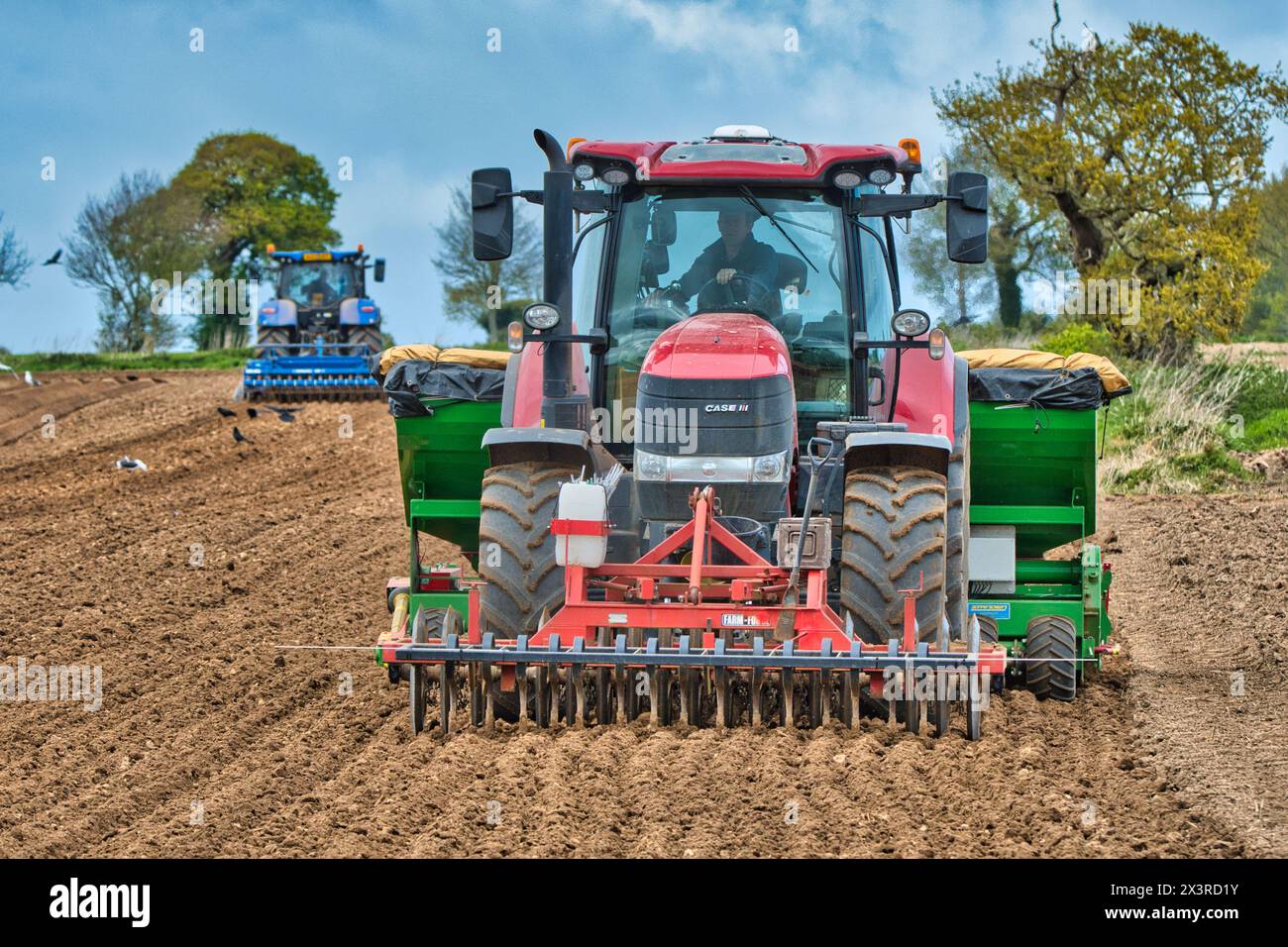 Tractor's carrying out deep bed drilling, preparing for potato planting ...