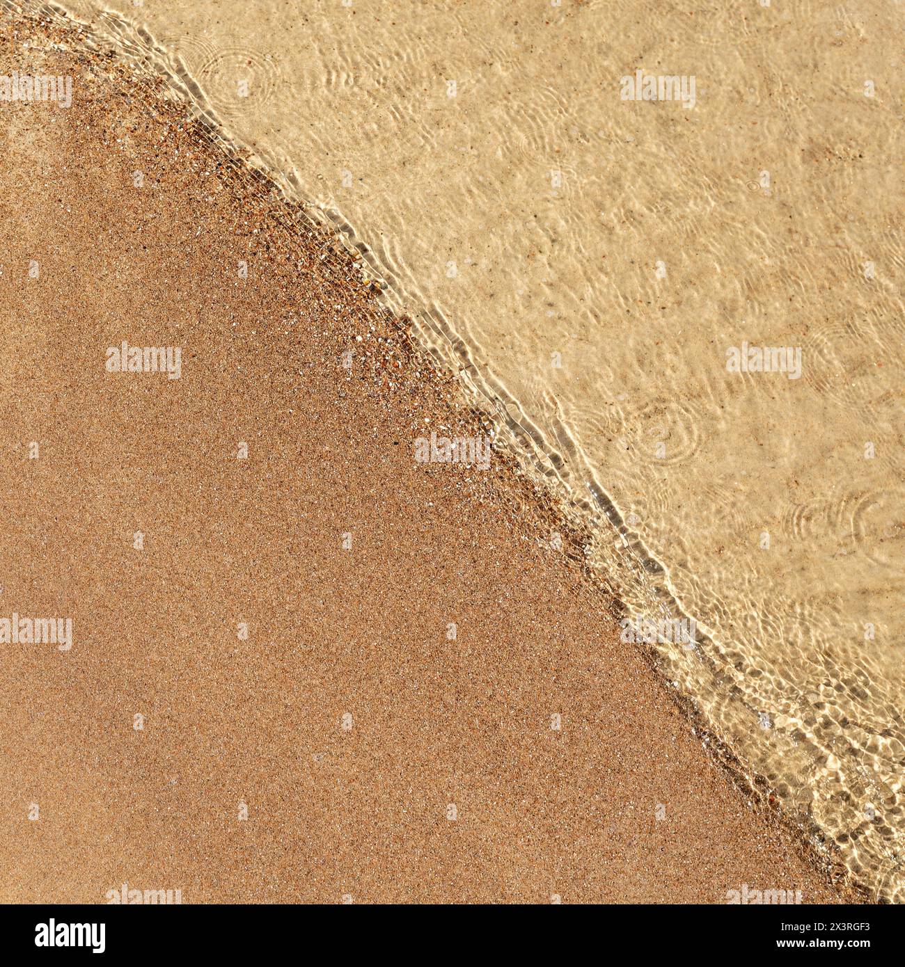 Diagonal line of crystal sea water on clean sand of beach. Close up ...