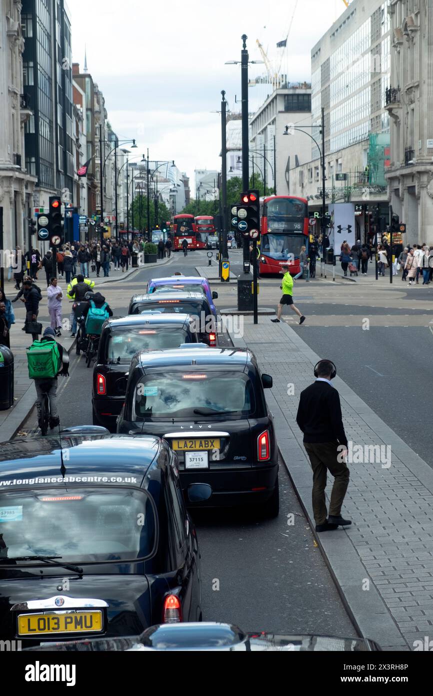 Traffic black taxi cabs queue and pedestrians from rear back behind on ...