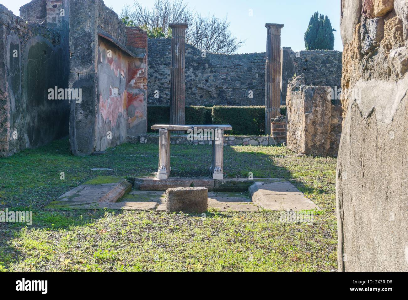 Table made out of stone surrounded by grass in ruins of ancient roman ...