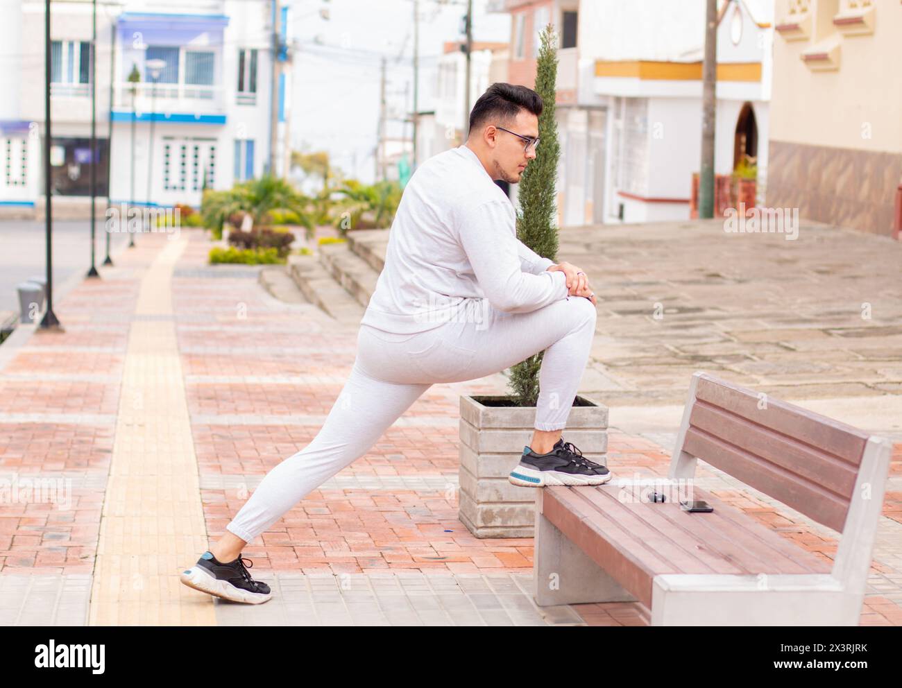 lifestyle: young man does stretching before starting his cardio routine ...