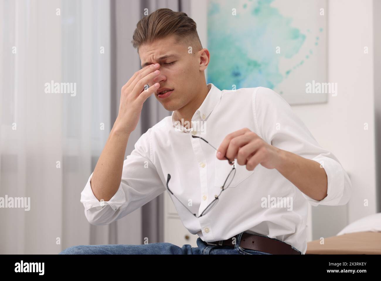 Overwhelmed man with glasses suffering at home Stock Photo - Alamy