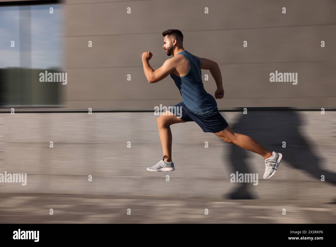Sporty young man running on street. Motion blur effect showing his ...