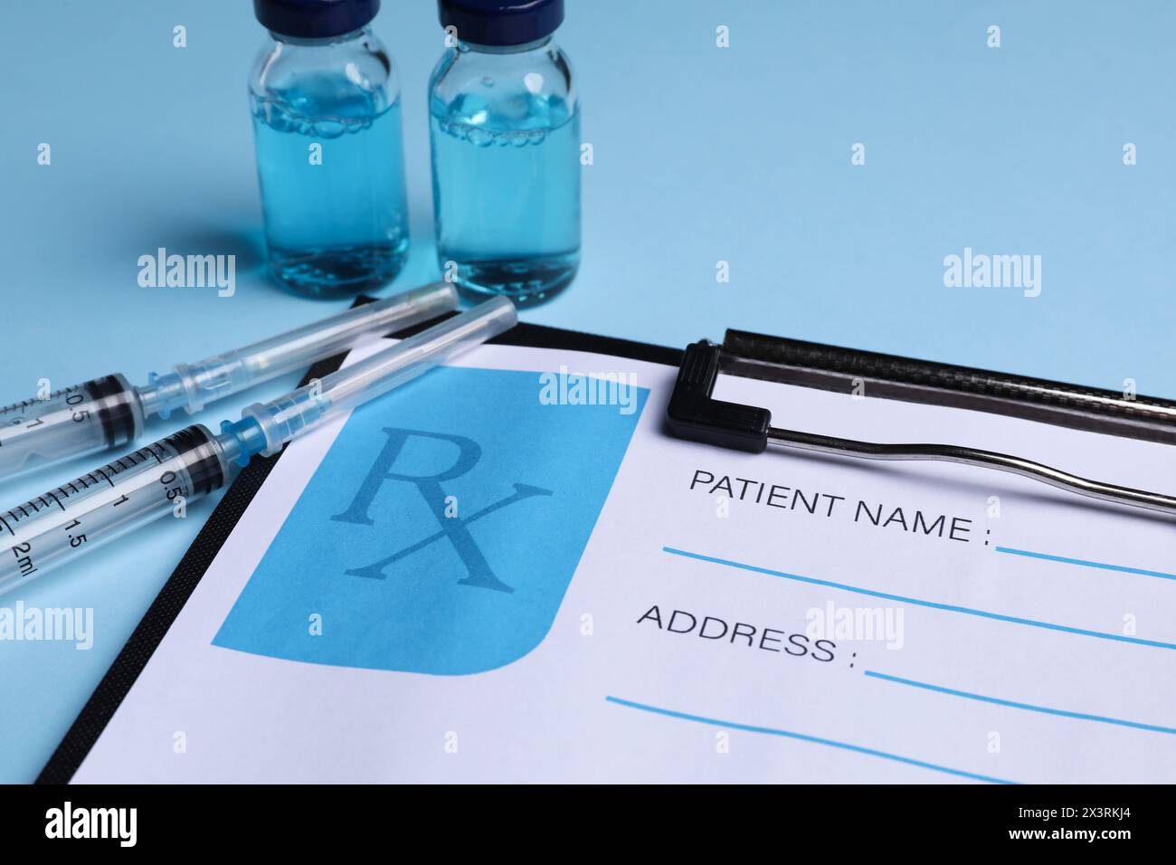 Clipboard with medical prescription form, syringes and glass vials on ...