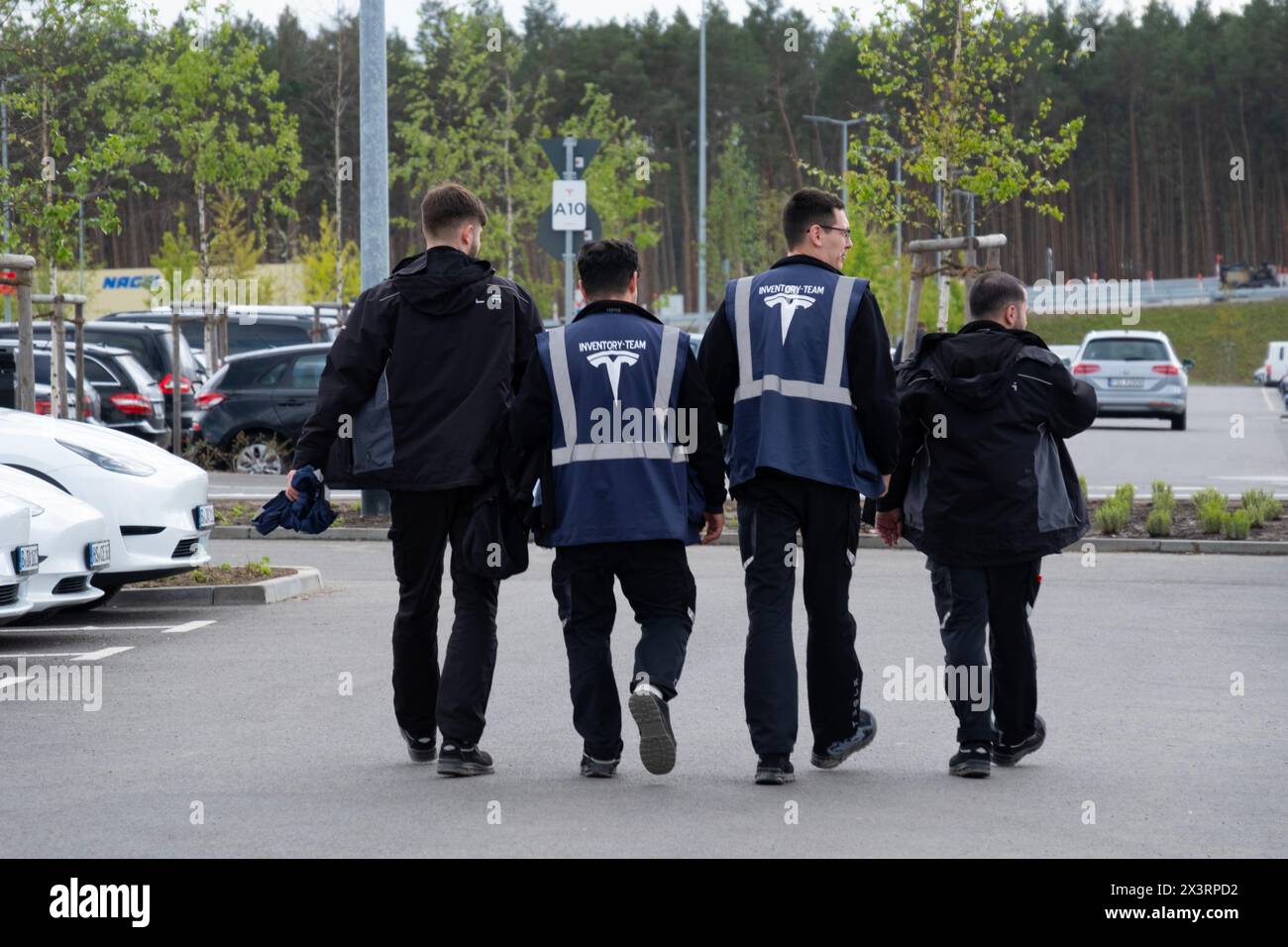 Factory workers leaving men, people in uniforms with Tesla logos coming ...