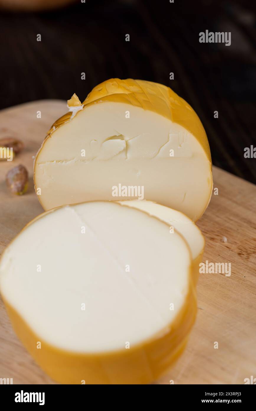 round processed cheese on the table, sausage cheese made from cow's ...