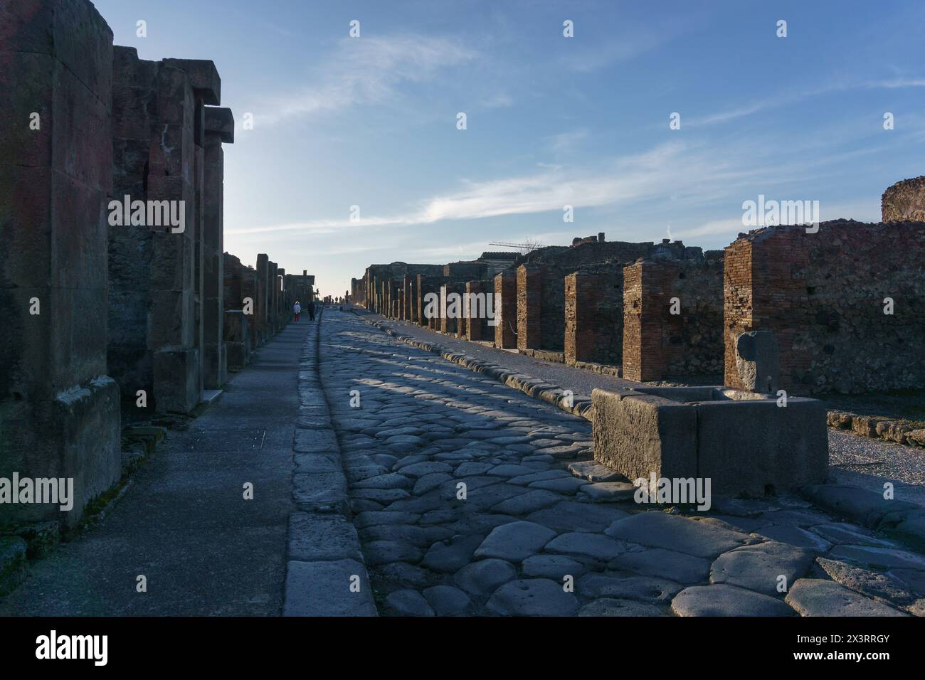 Roman street through the ruins during golden hour at sunset, Pompeii ...