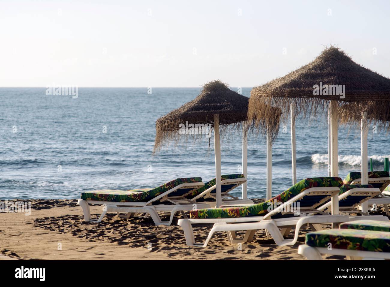 Sun loungers and umbrellas on the beach to relax while sunbathing in ...
