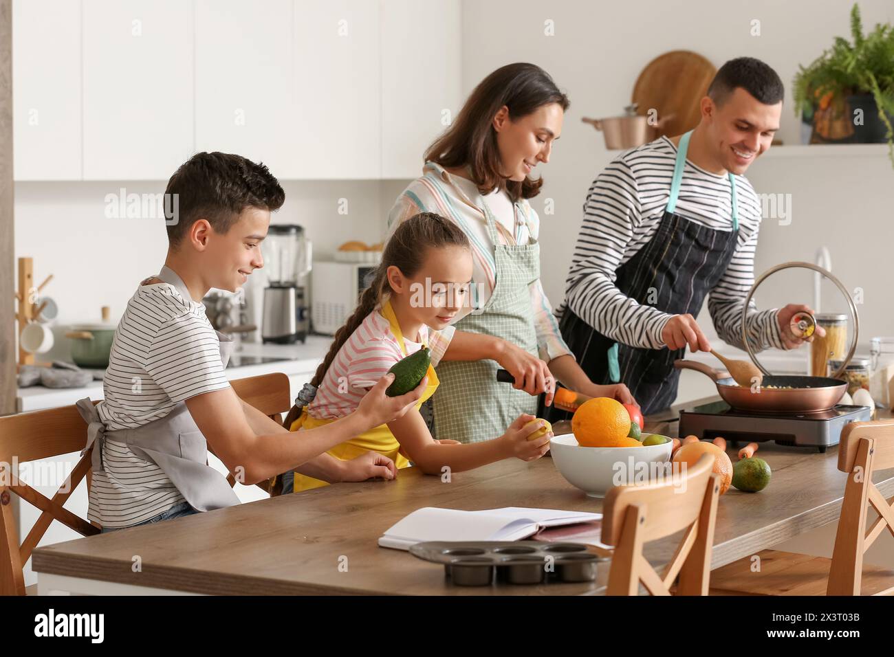 Happy family cooking in kitchen Stock Photo - Alamy