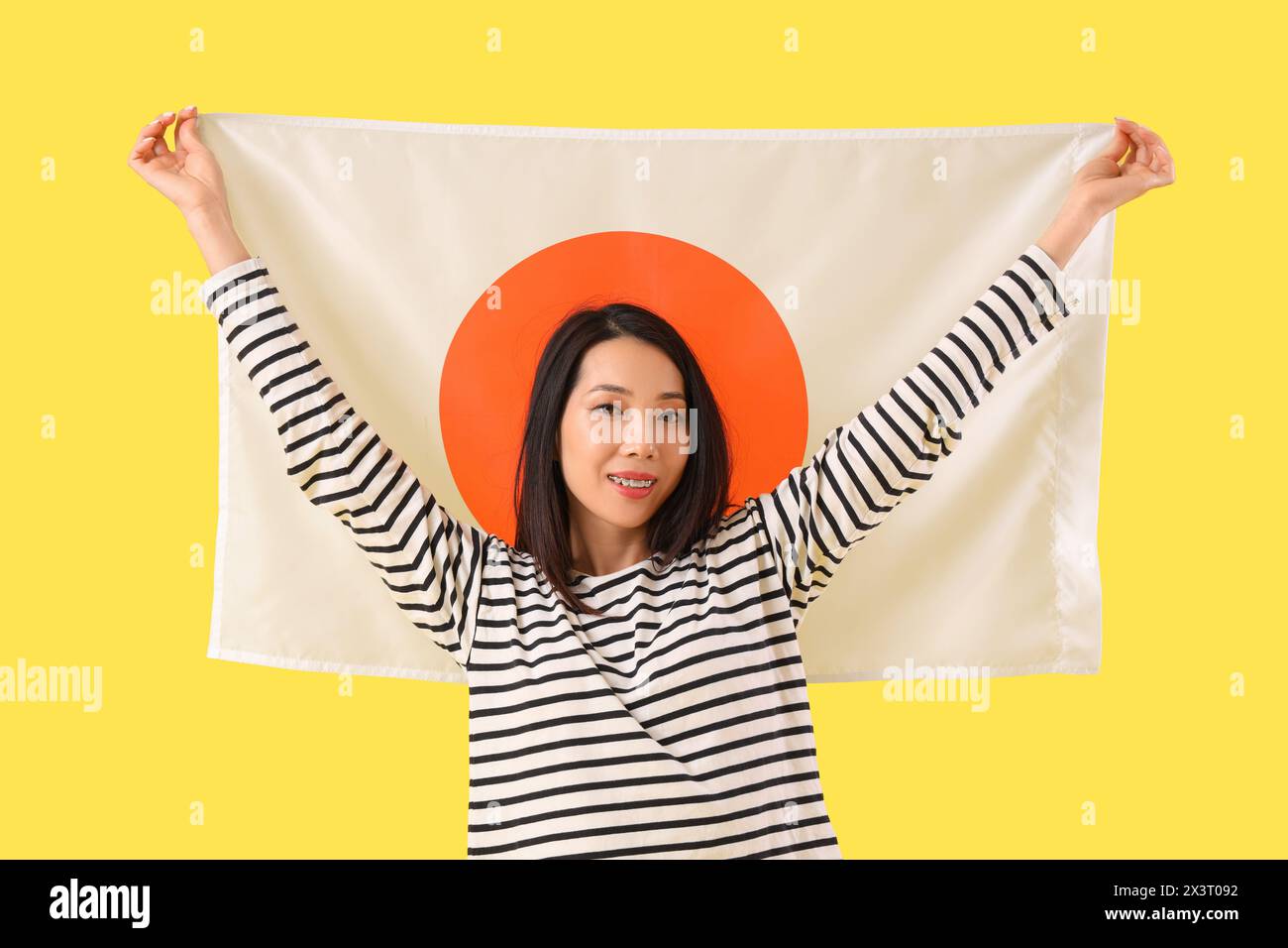 Young Asian woman with flag of Japan on yellow background Stock Photo ...