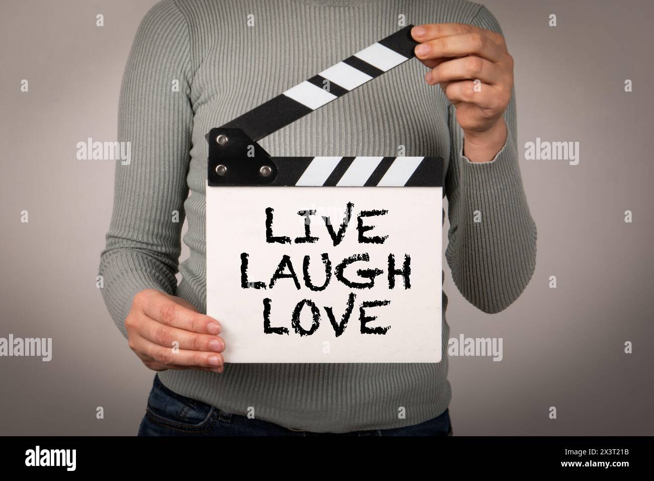 Live Laugh Love. Female hands holding movie clapper Stock Photo - Alamy