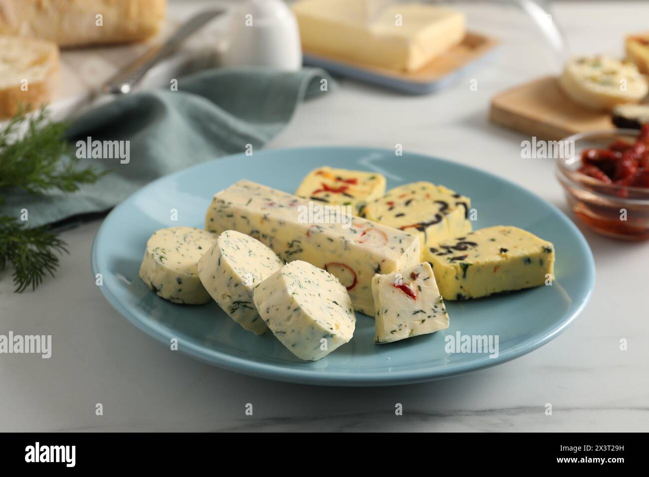 Different types of tasty butter and chili pepper on white marble table ...