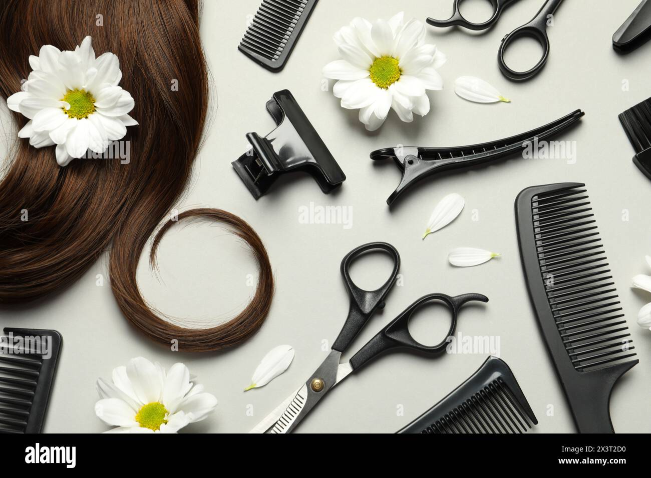 Flat lay composition with professional hairdresser tools, flowers and ...