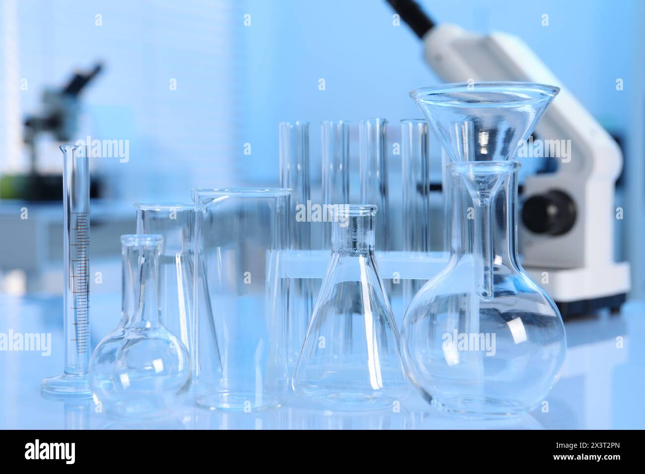 Laboratory analysis. Different glassware and microscope on white table ...