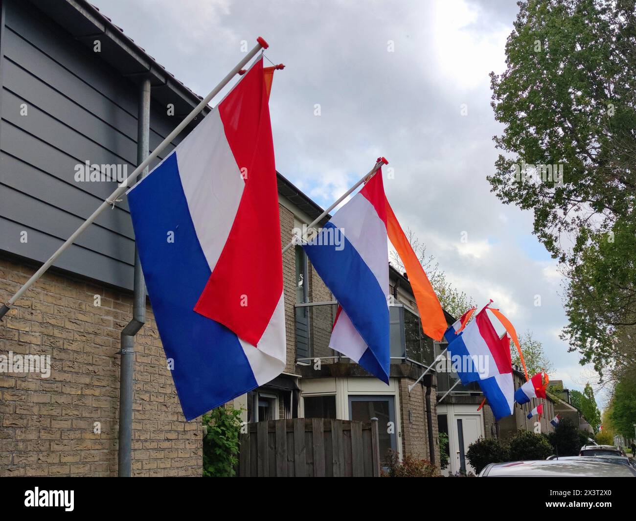 View of a row of colorful Dutch flags in a village street to celebrate ...