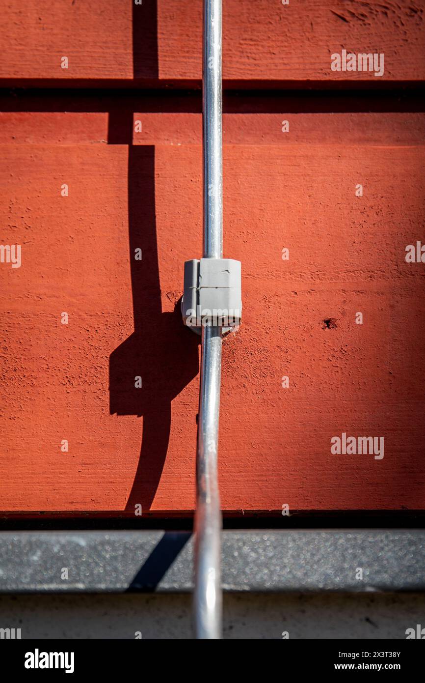 Lightning rod on the wall of a red wooden building. Architecture and ...