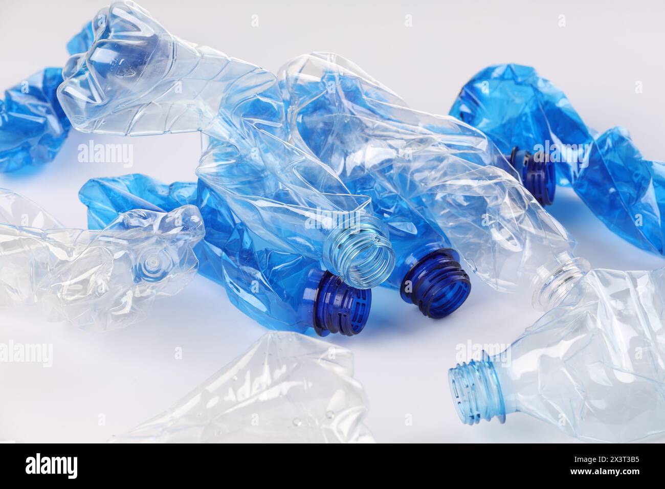 Crumpled disposable plastic bottles on white background Stock Photo - Alamy