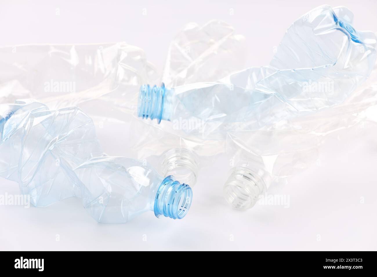 Crumpled disposable plastic bottles on white background Stock Photo - Alamy