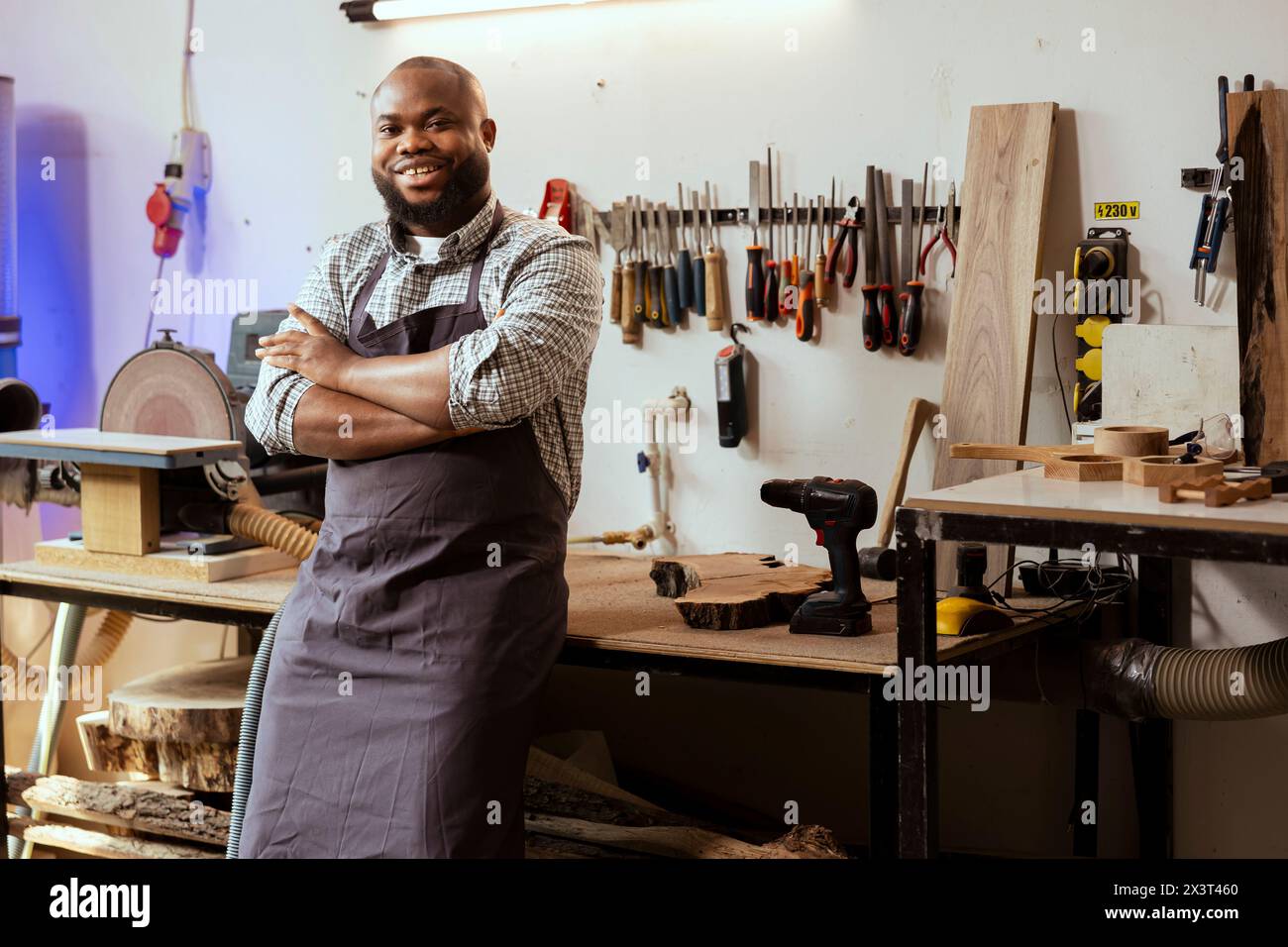 Portrait of smiling african american carpenter preparing to start production in messy furniture ...