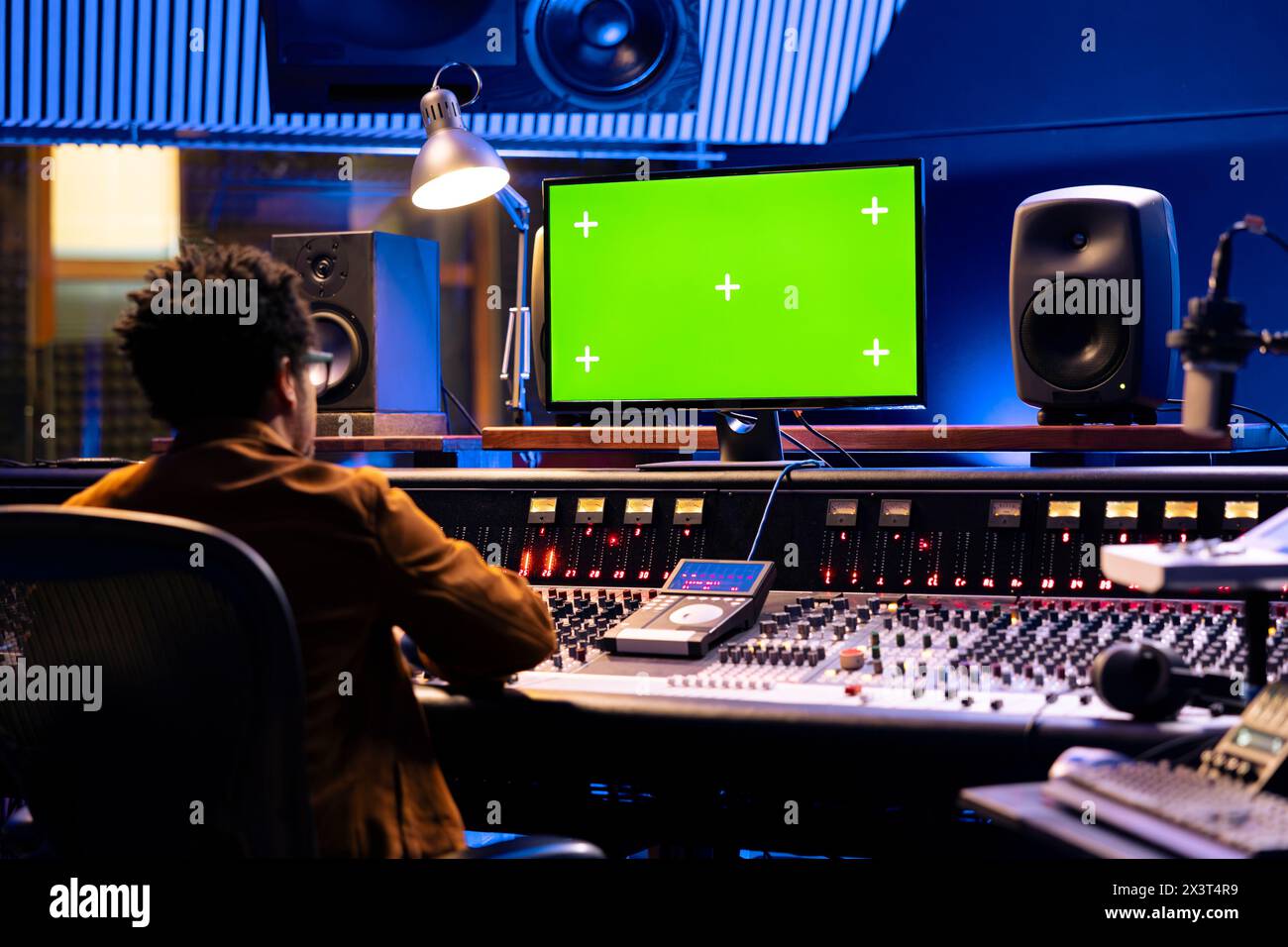 African american sound designer works with greenscreen monitor, mixing ...