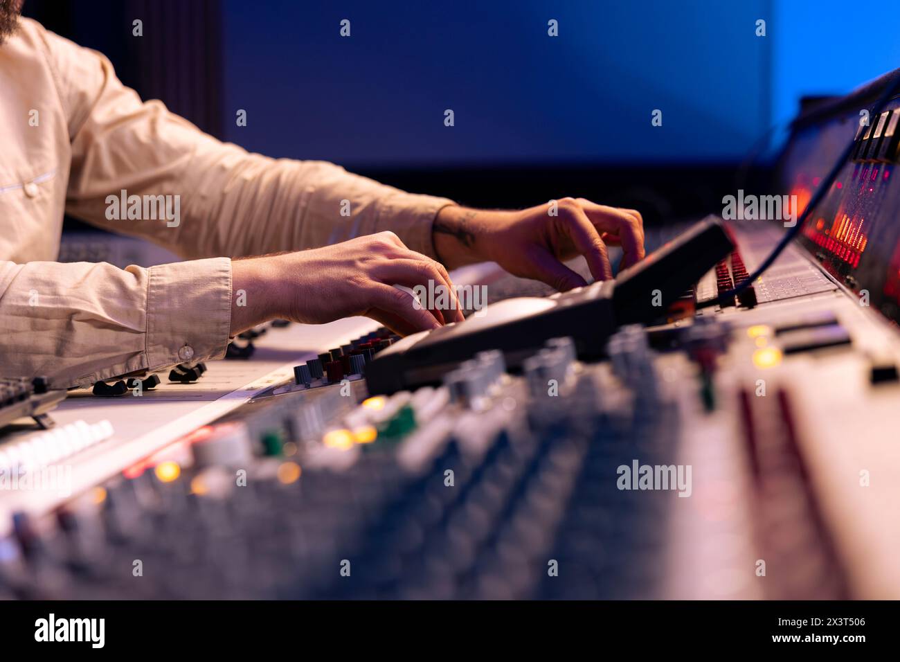 Audio expert uses mixing console and switchers on control room panel ...
