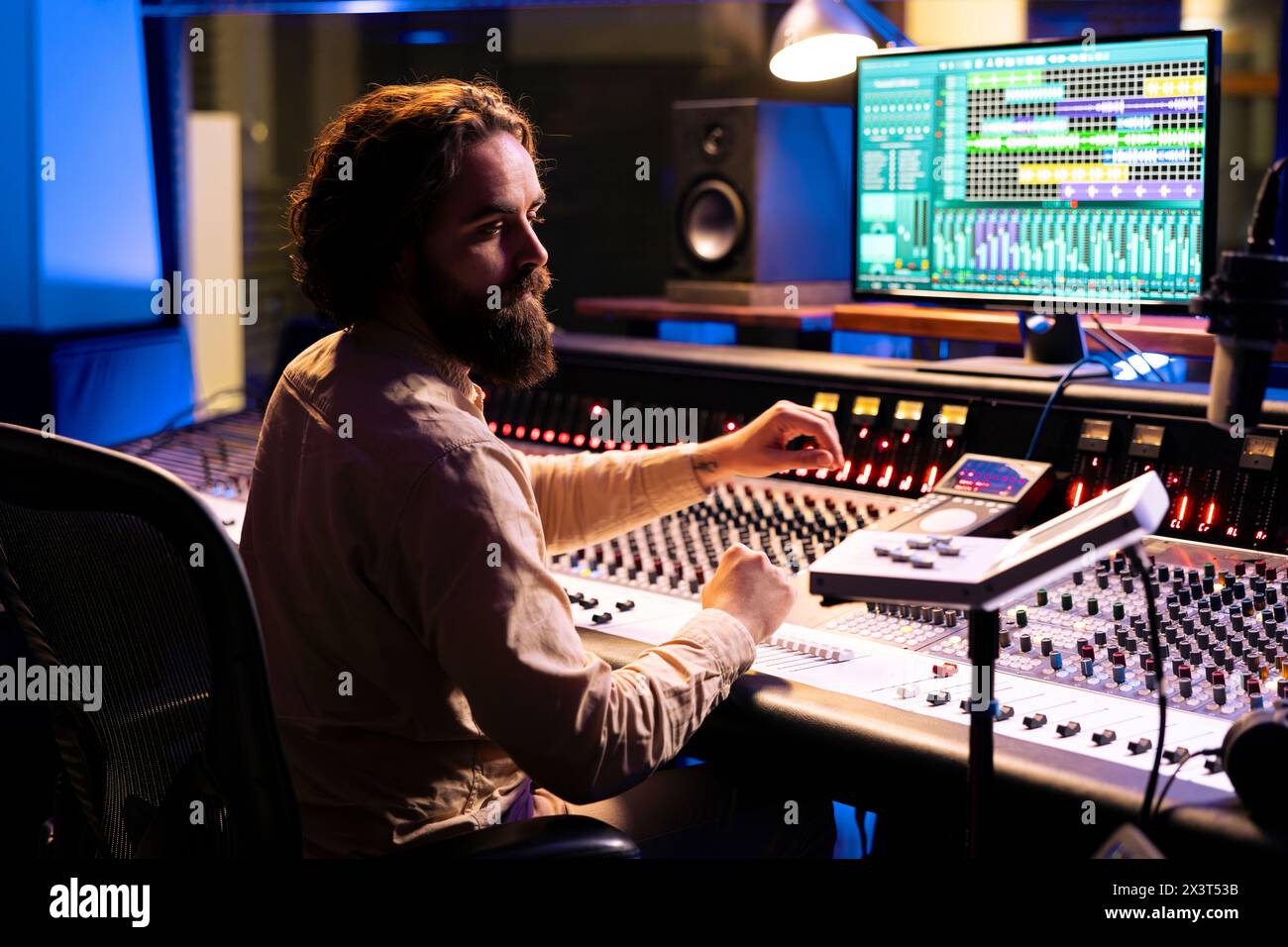 Music technician mixing and mastering songs with motorized faders and ...