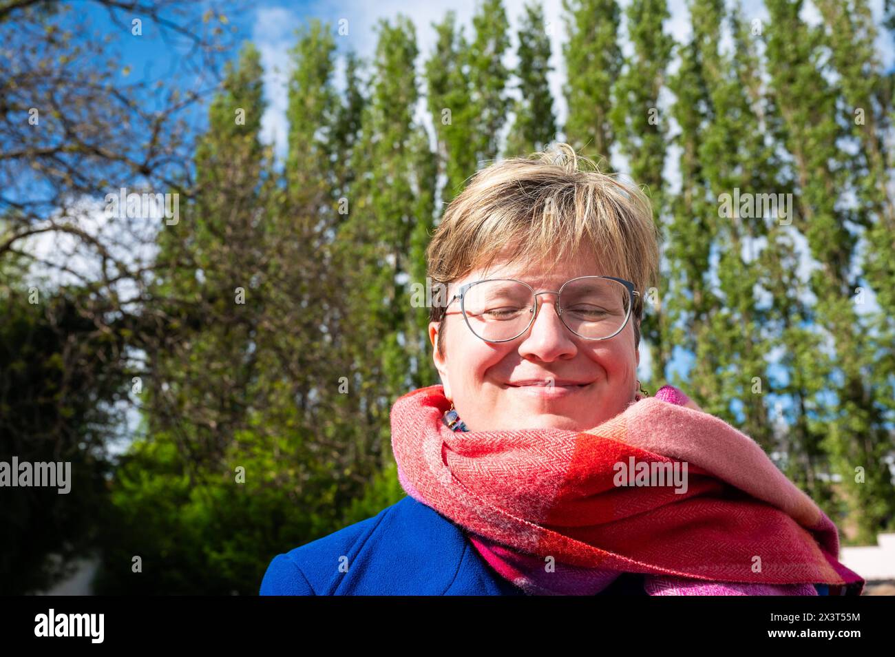 Colorful portrait of a 38 yo white woman outdoors, eyes closed ...