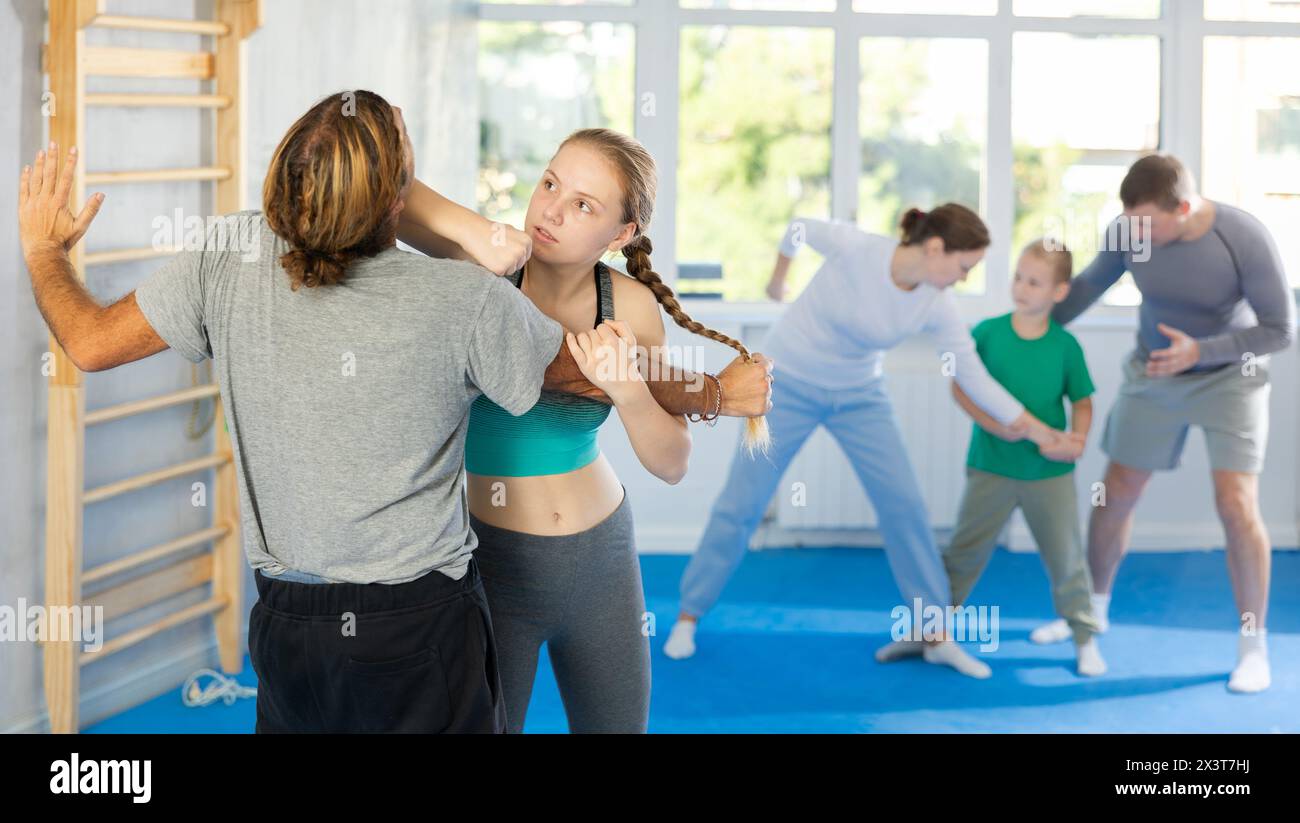 Teen girl in gym perform basic elements of krav maga self-defense ...