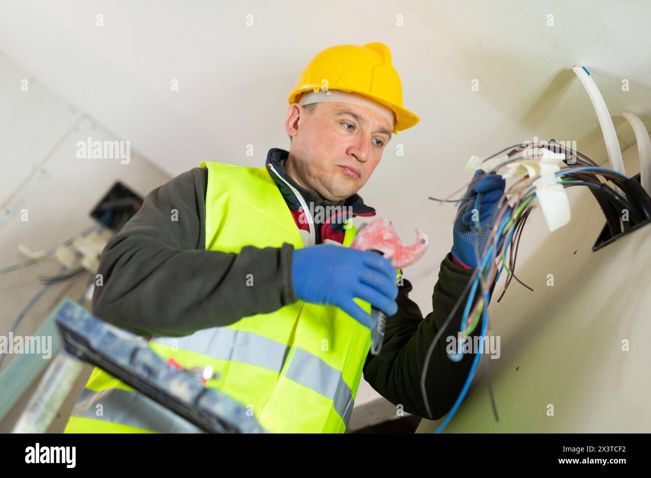 Electrician working with wires in apartment Stock Photo - Alamy