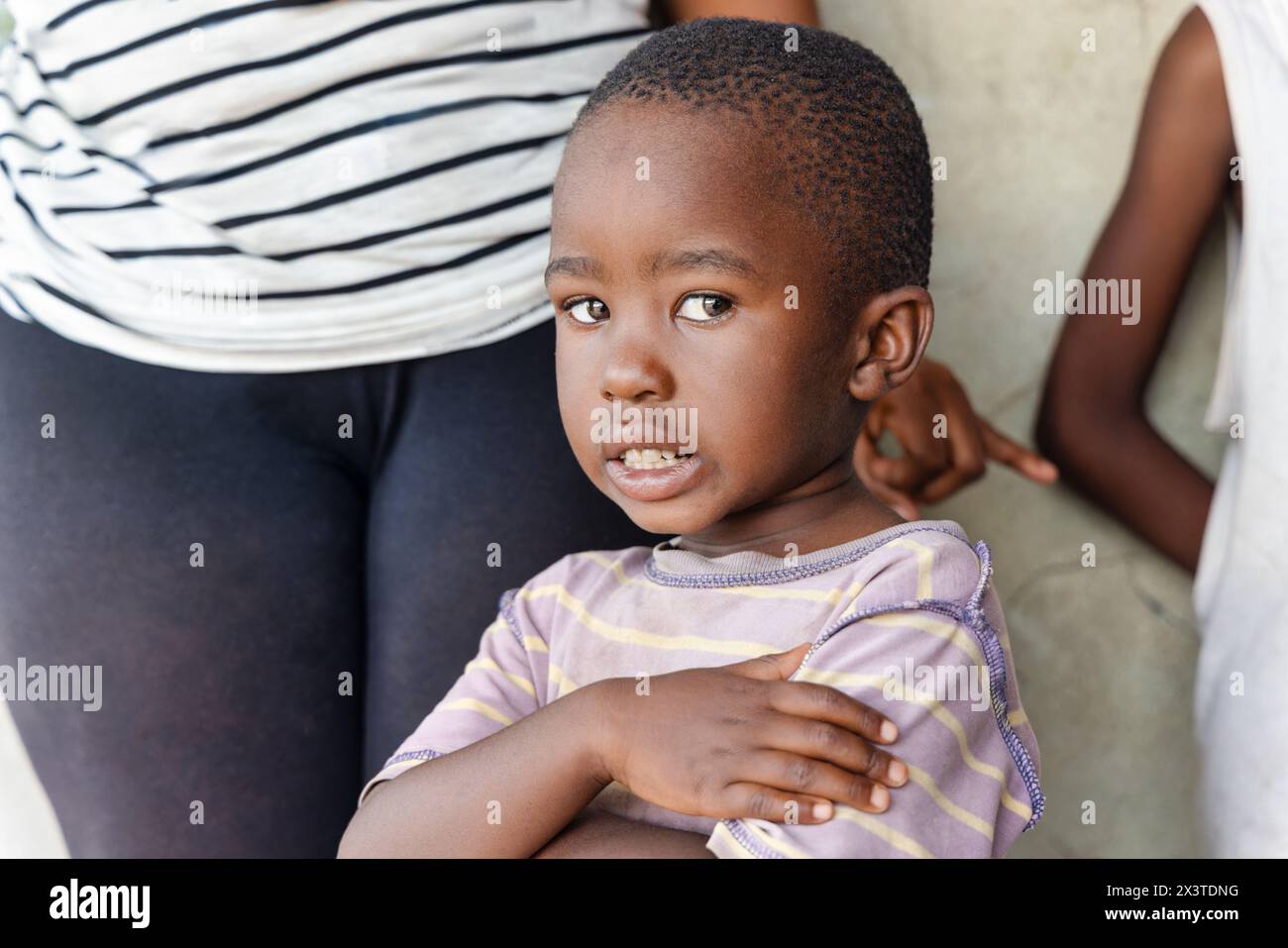 african village , african boy standing in front of the house on the ...
