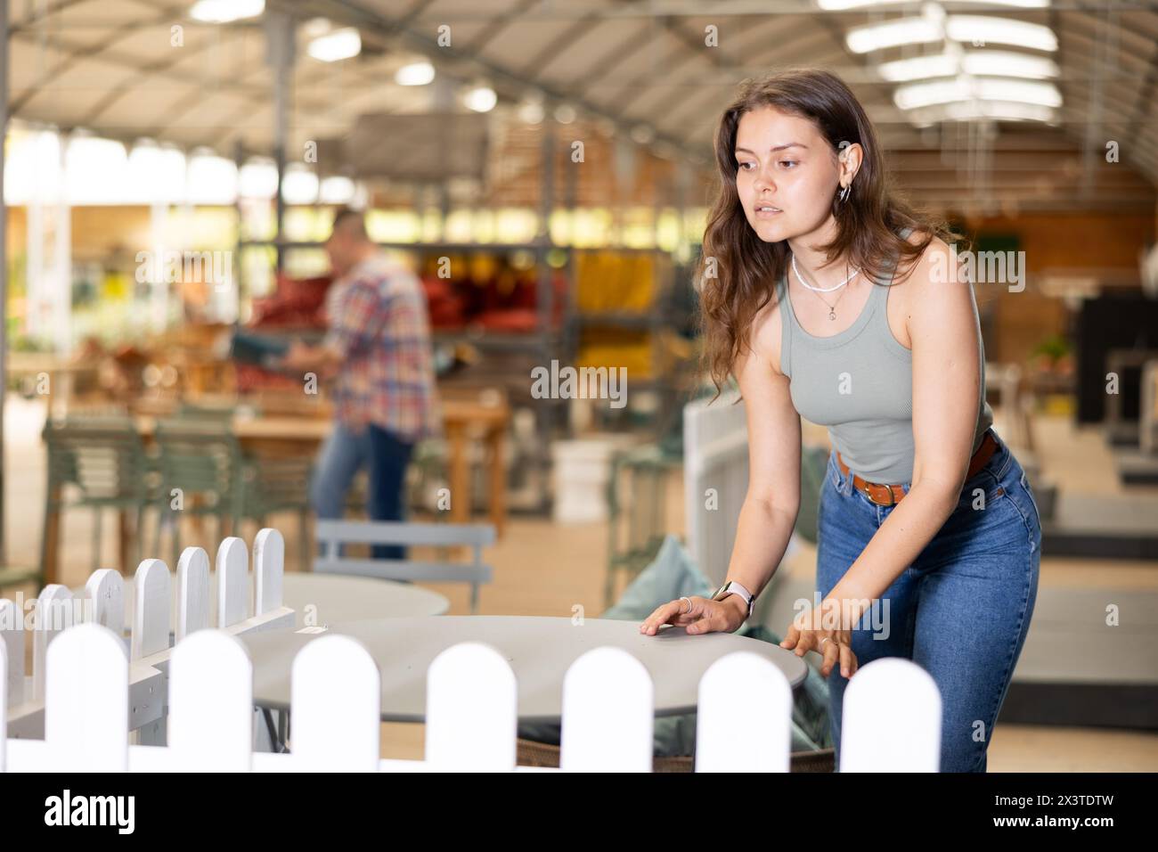 Girl buyer choose table desk in garden furniture store showroom Stock ...