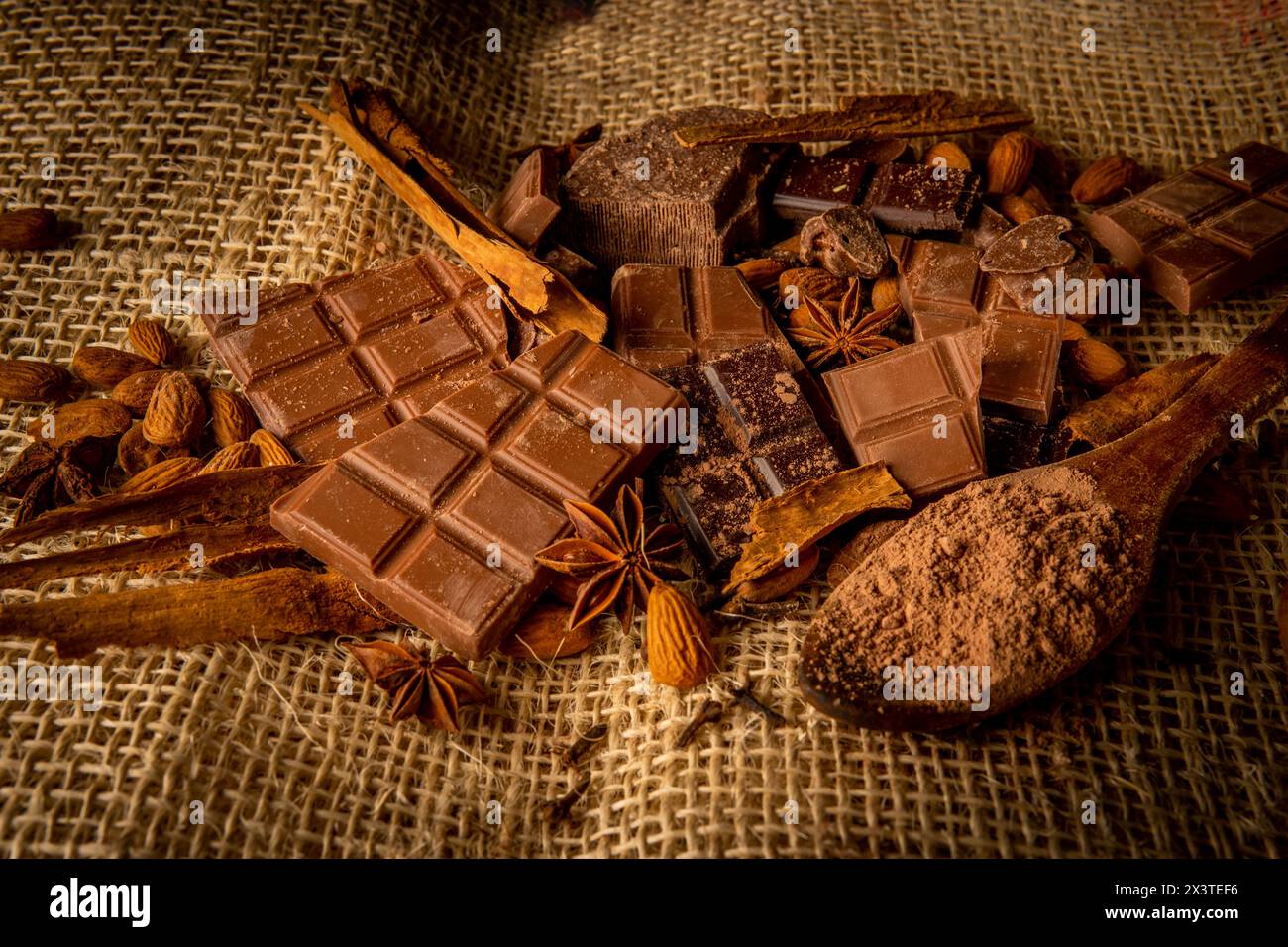 Chocolate and spices on a rustic jute background. Chocolate and cocoa ...