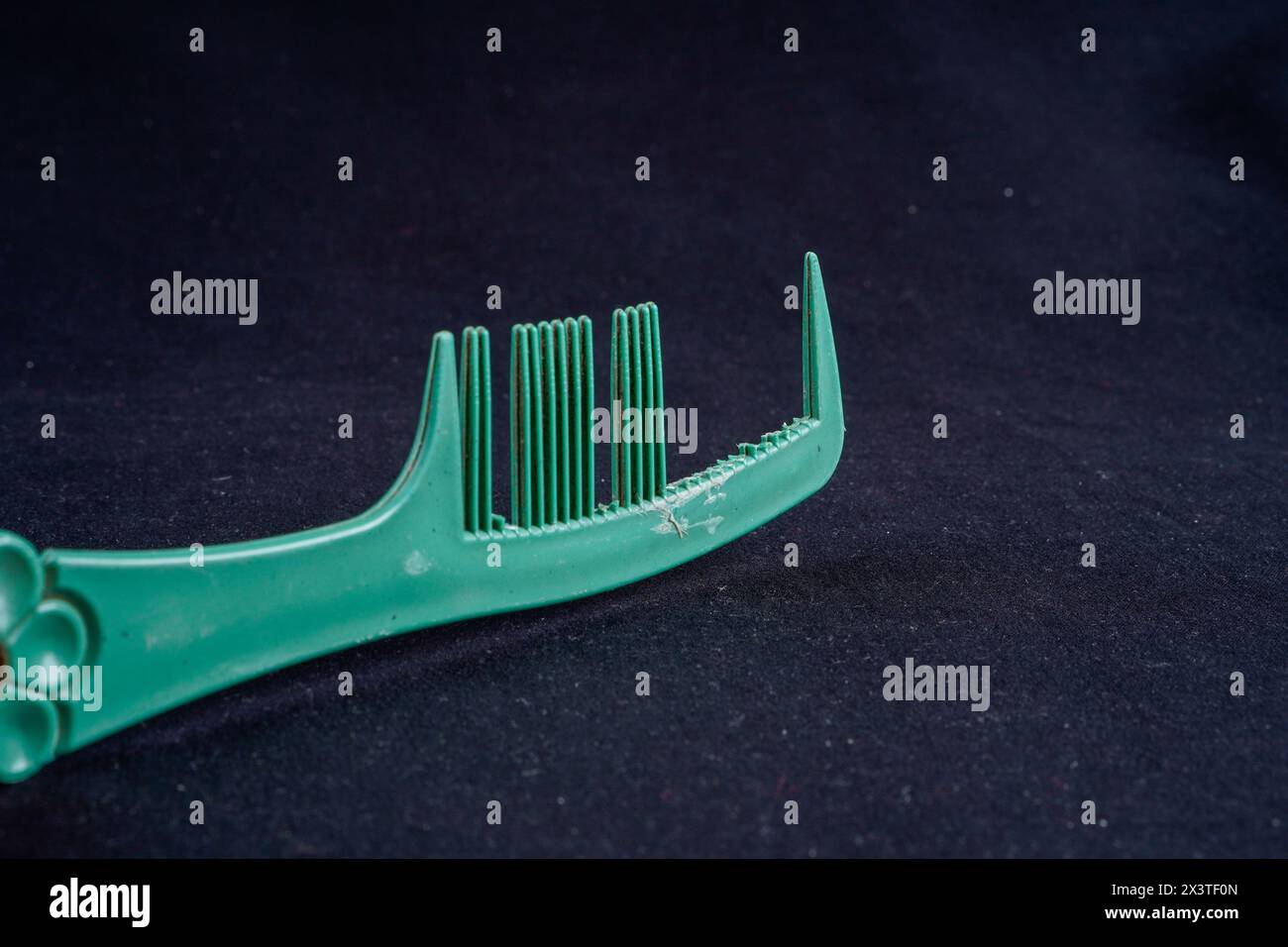 close up of a broken toothed comb on a black background with empty ...