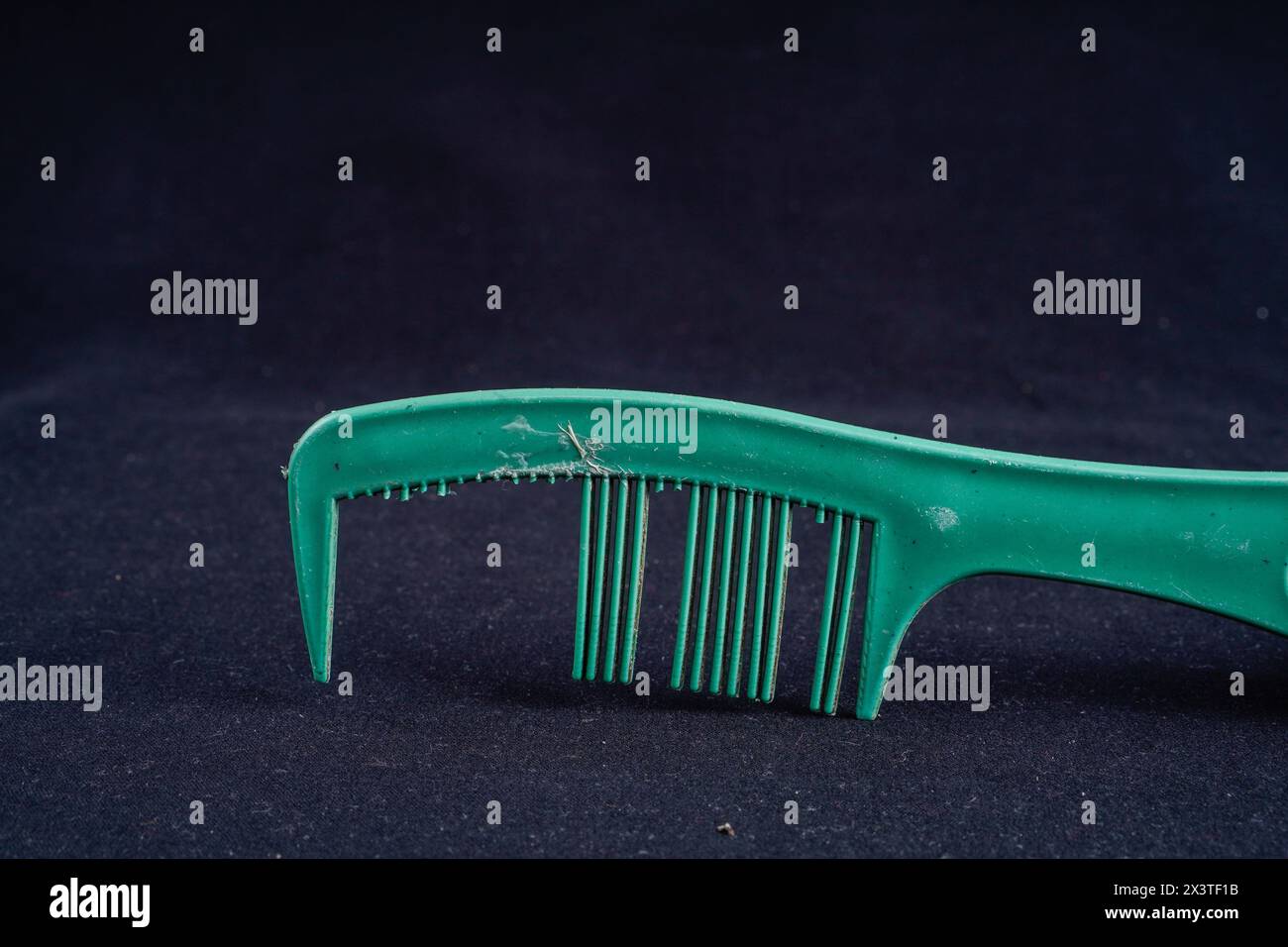 close up of a broken toothed comb on a black background with empty ...