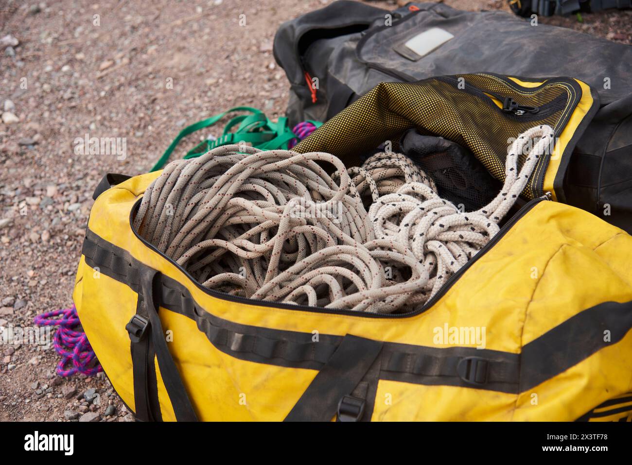 Yellow open duffel bag full of ropes and strings, outdoors. Close up ...