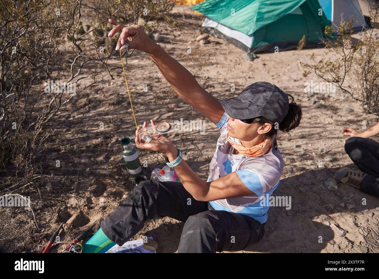 Woman hiker sitting at her campsite with a baseplate orienteering ...