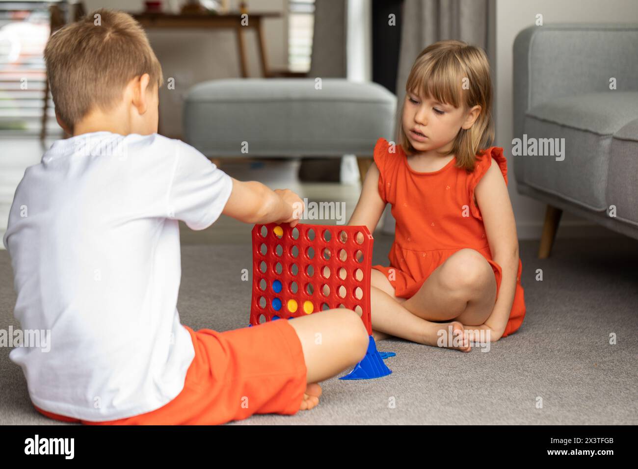 Siblings engrossed in a strategic board game, enhancing their logic ...