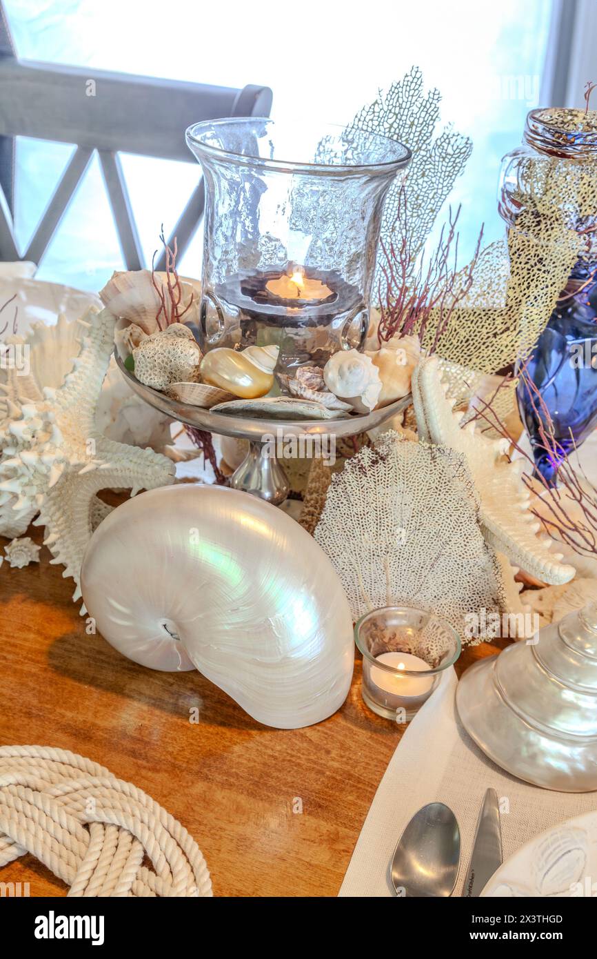 Seashell and candle decoration on a nautical table setting with natural ...