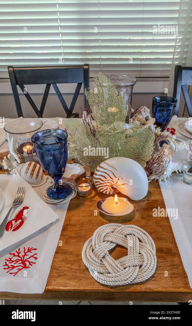 Seashell and candle decoration on a nautical table setting with natural ...