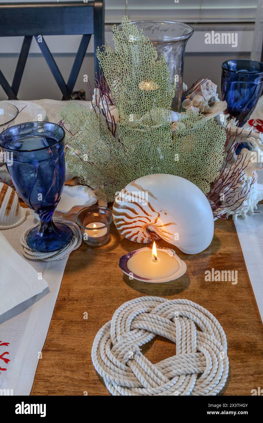 Seashell and candle decoration on a nautical table setting with natural ...