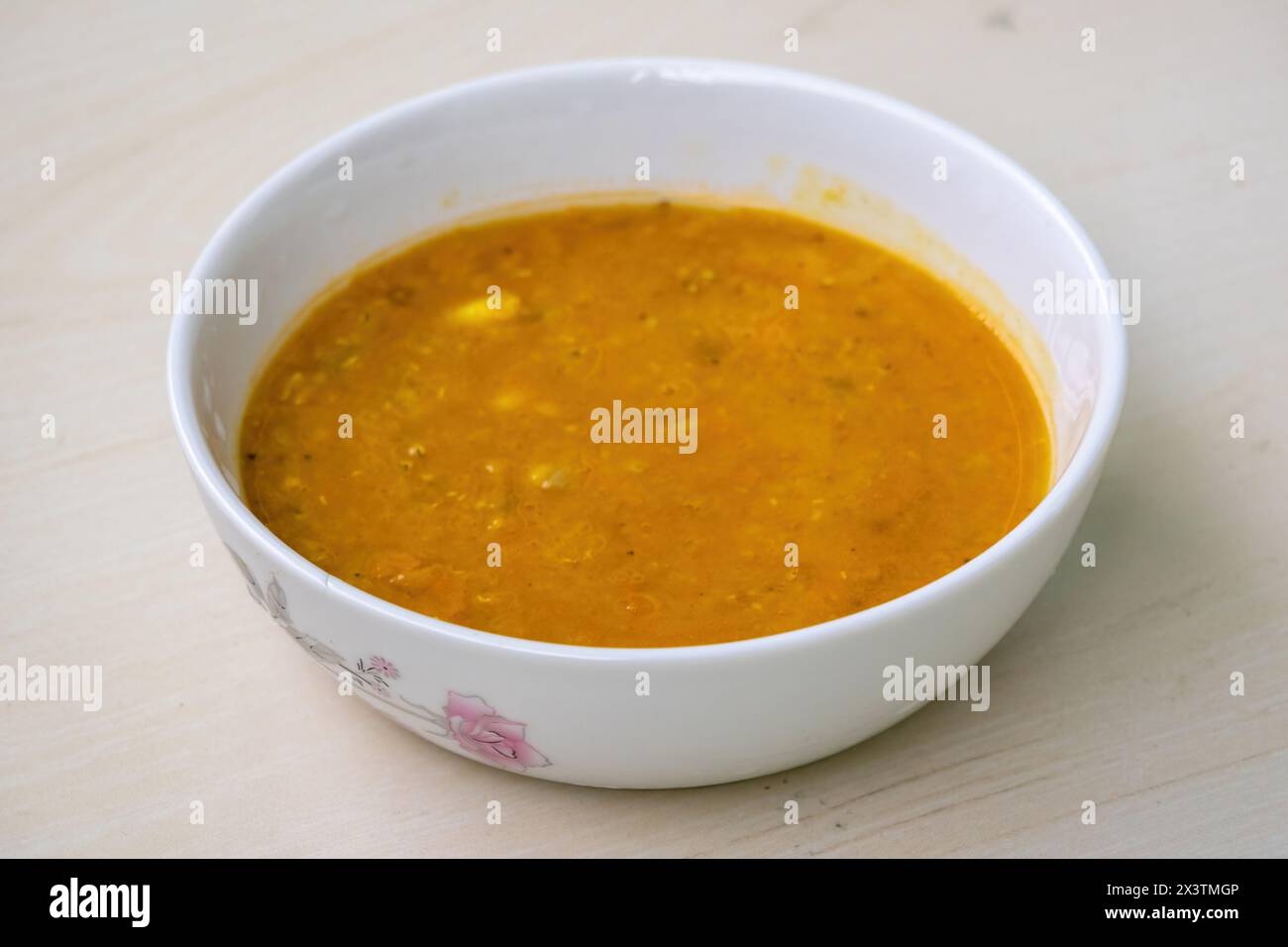 Red lentil or masoor dal bhuna or ghono dal in a white bowl on wooden ...