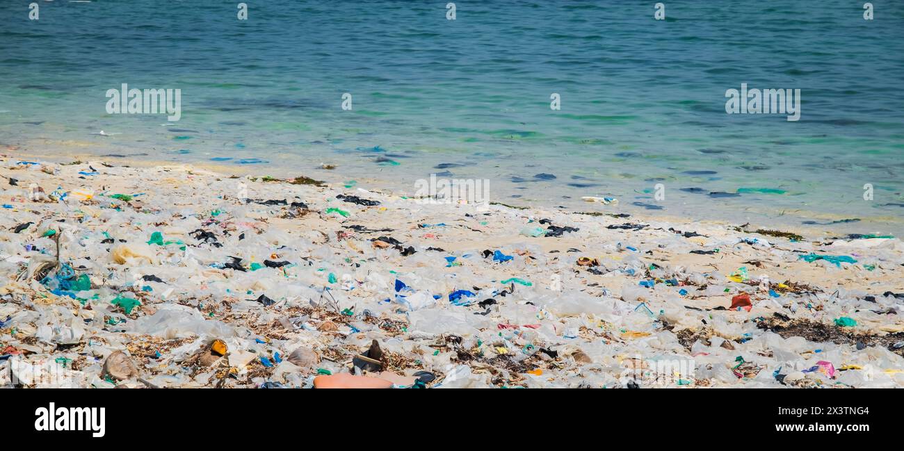 Spilled garbage on beach of big city. Empty used dirty plastic bottles ...