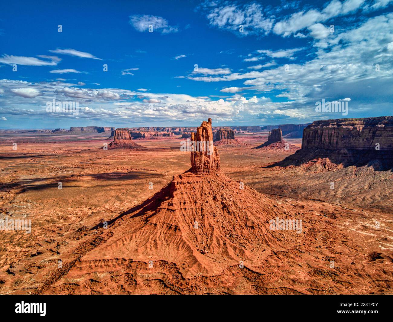 A large rock formation stands imposingly in the middle of a vast desert ...