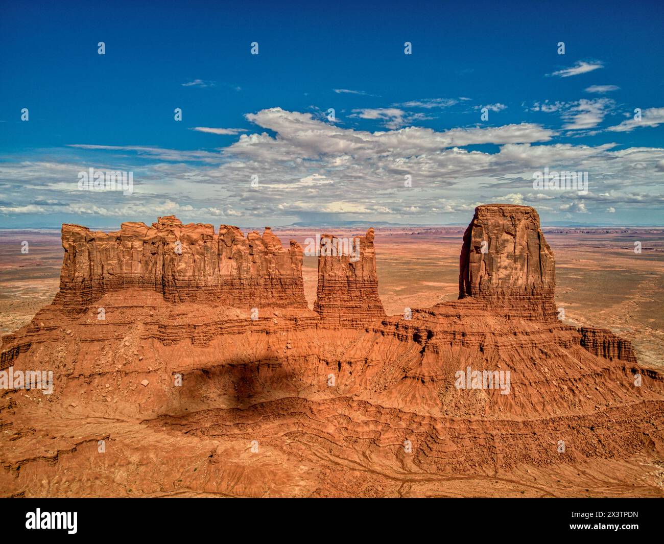 A large rock formation stands prominently in the arid landscape of ...